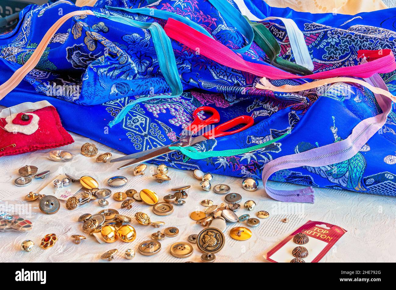 Colourful cottons, buttons and fabrics used in the craft of fastening ...