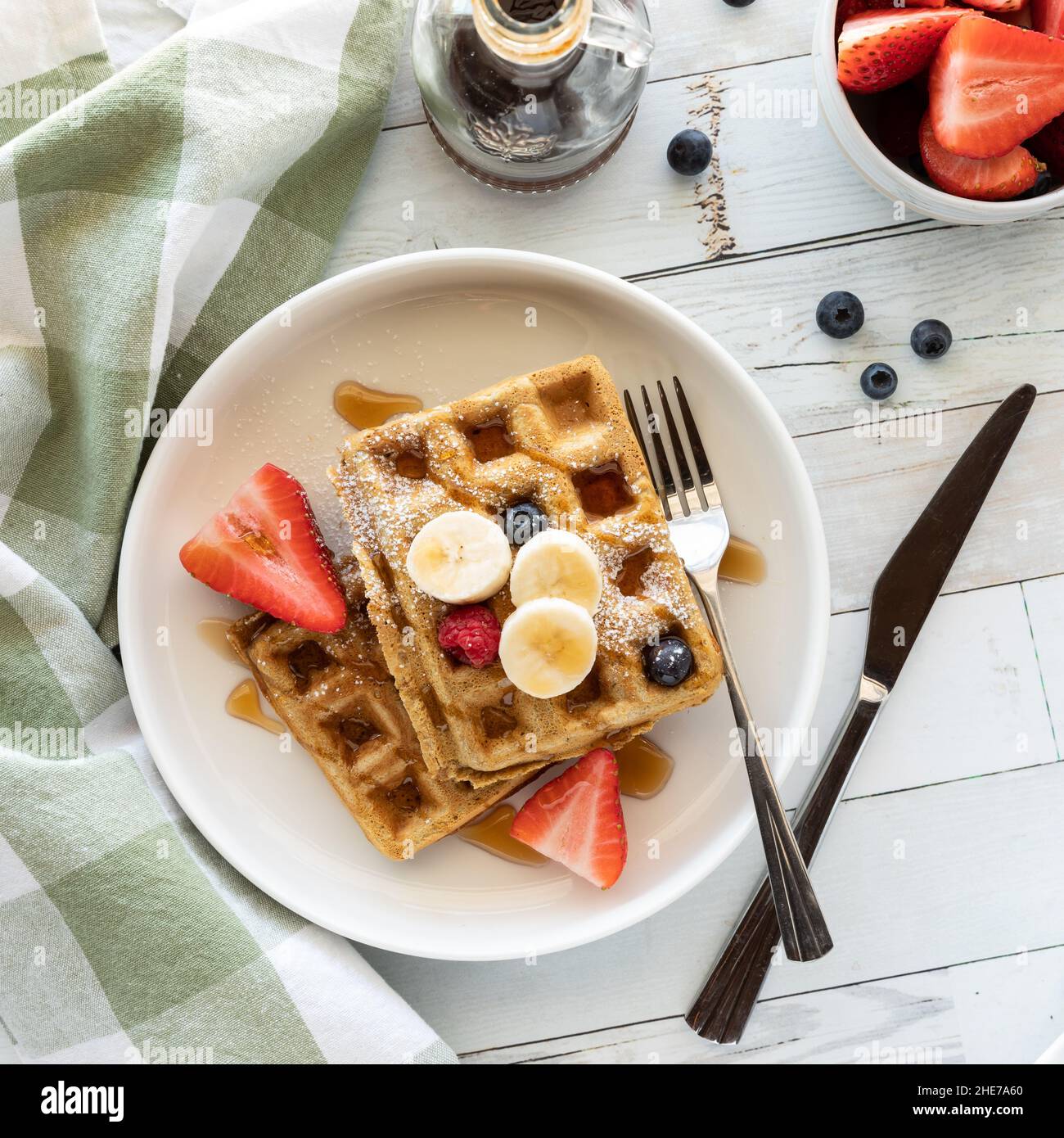 Whole grain waffles topped with fresh fruit and powdered sugar Stock ...