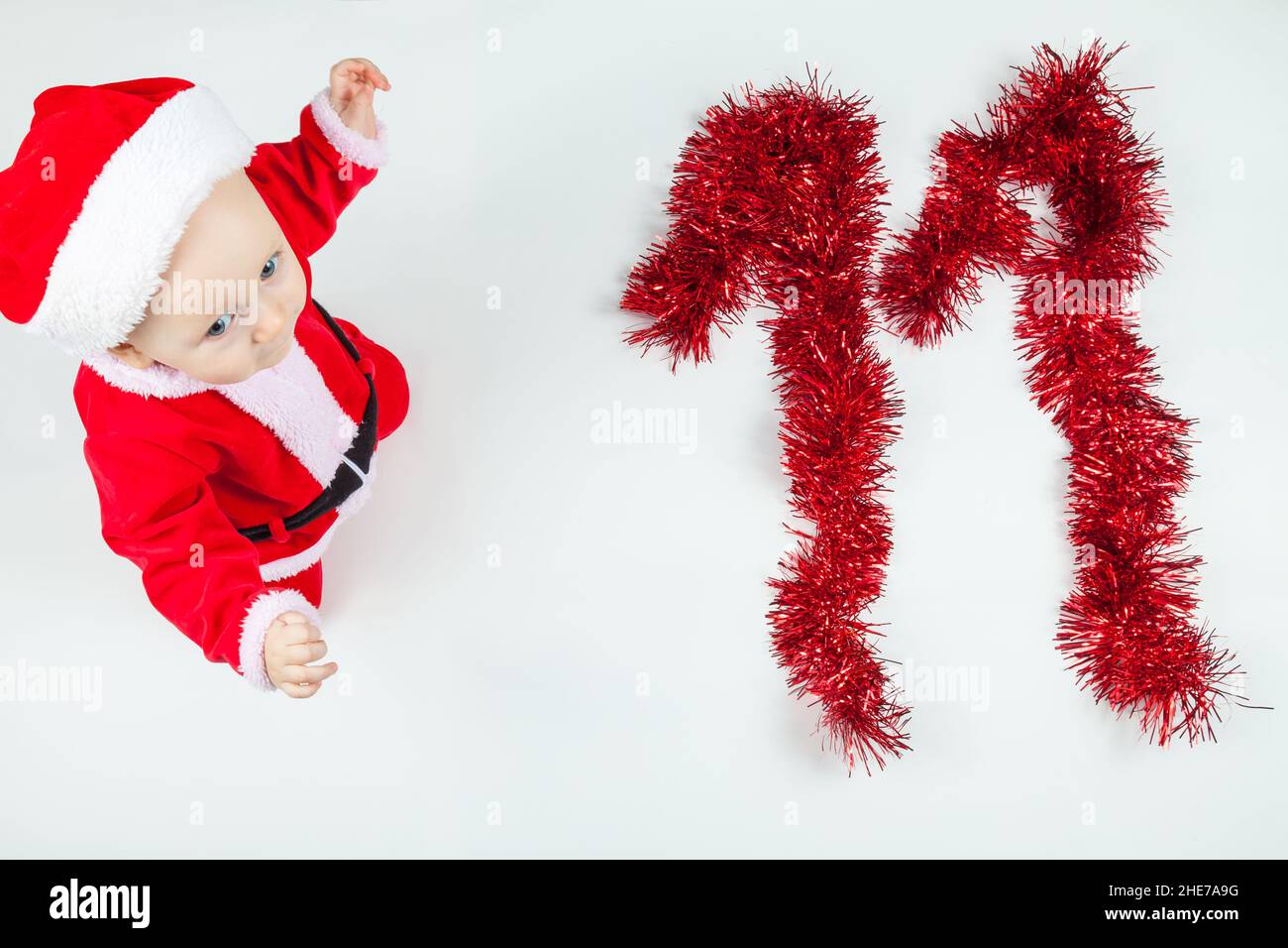 Smiling happy newborn infant eleven month baby in the red santa claus ...