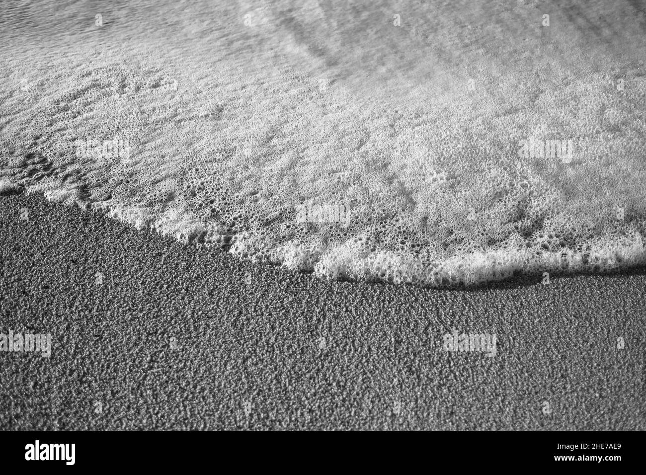Texture of the beach sand with the foam. Black and white photo Stock ...