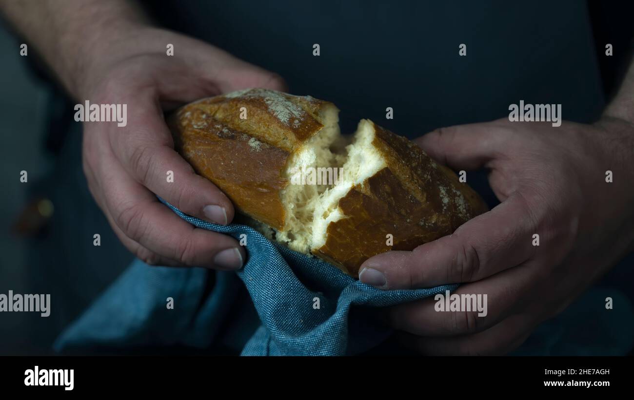 Baker holding organic bread bake bread rolls divided in half in hands ...