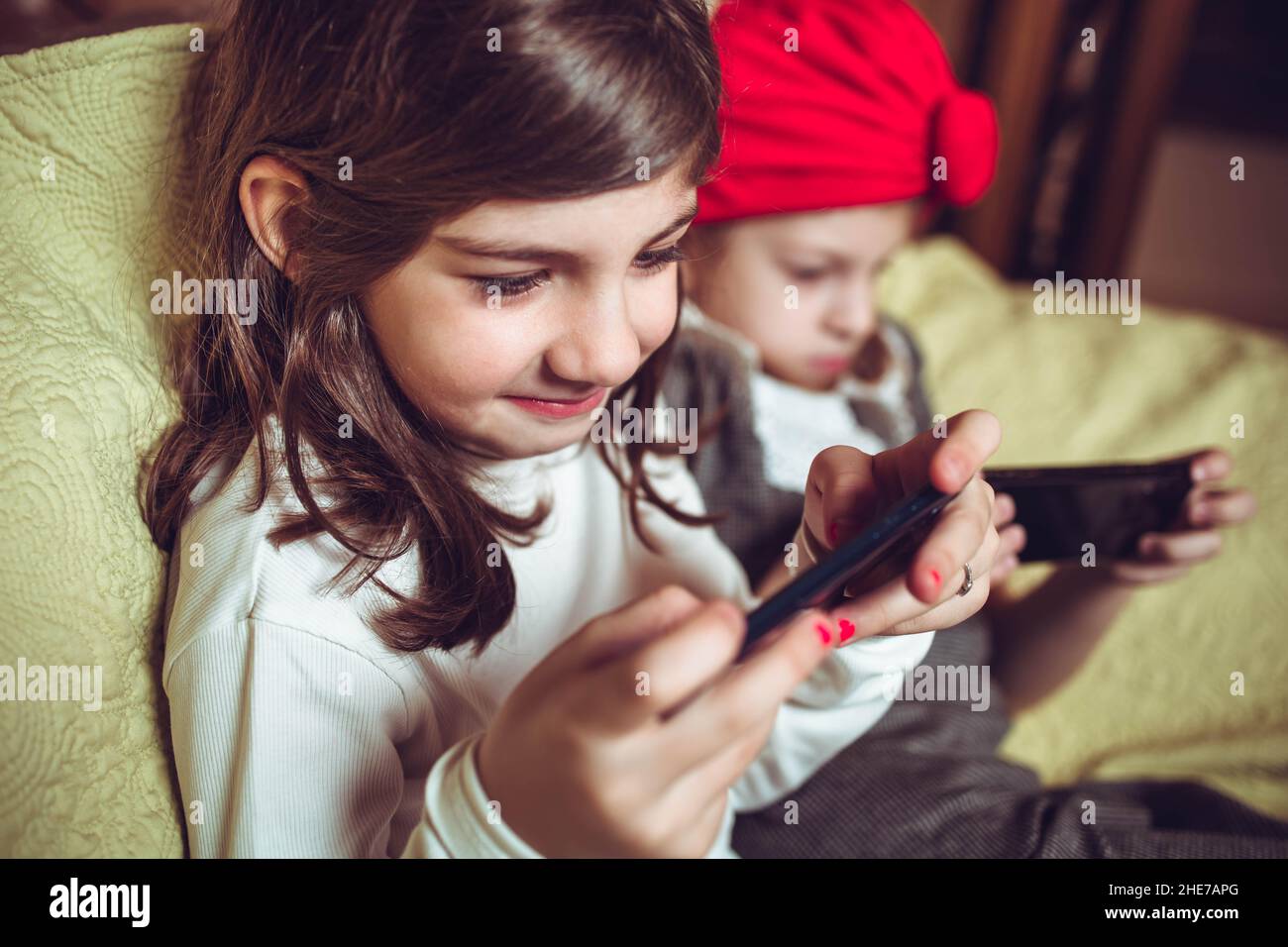 Little girls playing games on their mobile phones Stock Photo - Alamy