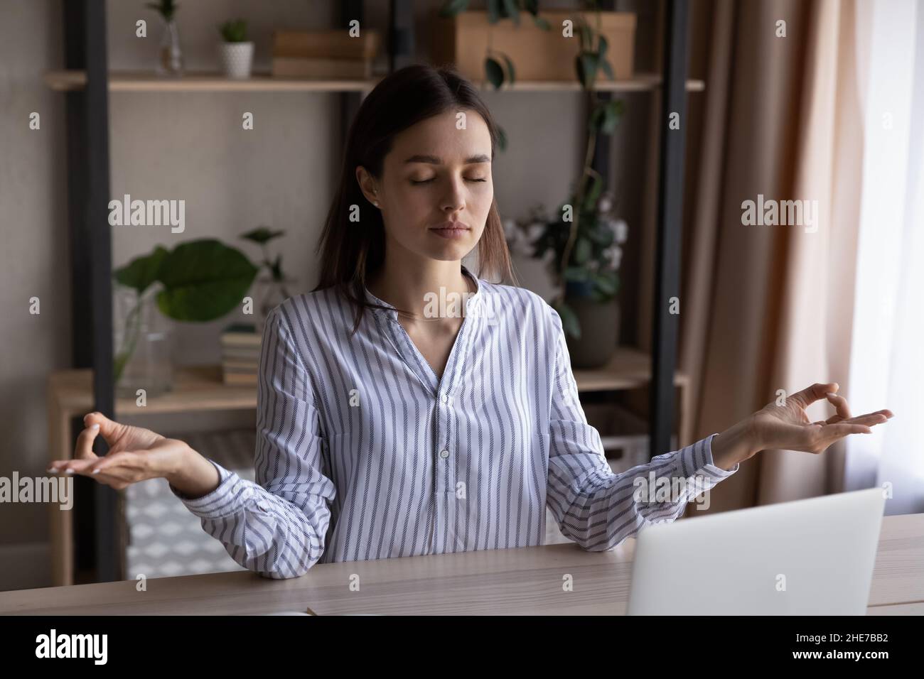 Peaceful calm woman meditating at office workplace with computer Stock ...