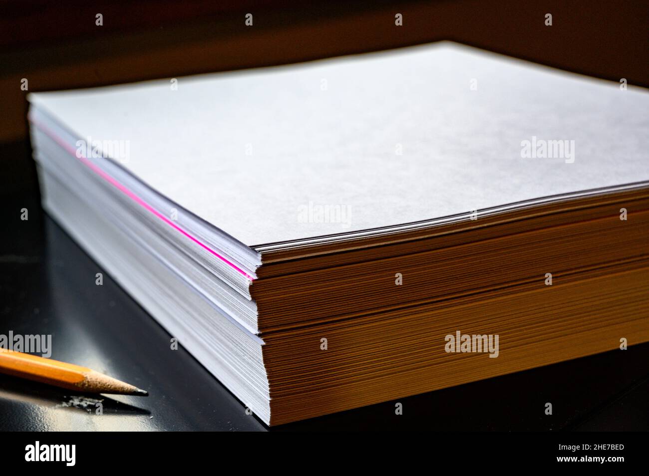 Selective focus on a single colored sheet in a stack of plain white ...