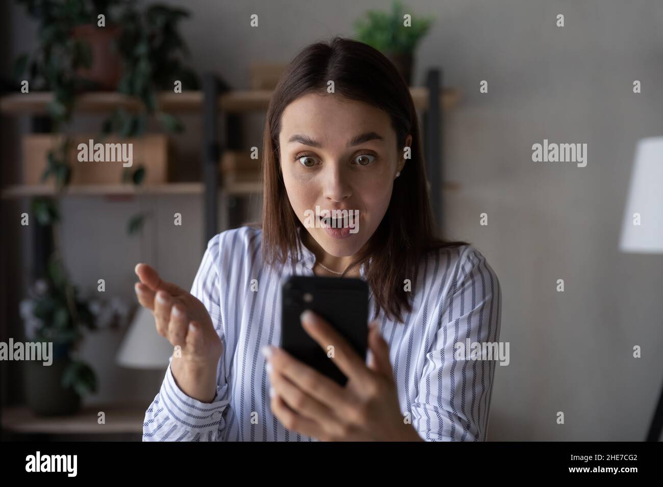 Shocked excited smartphone user staring at mobile phone screen Stock ...