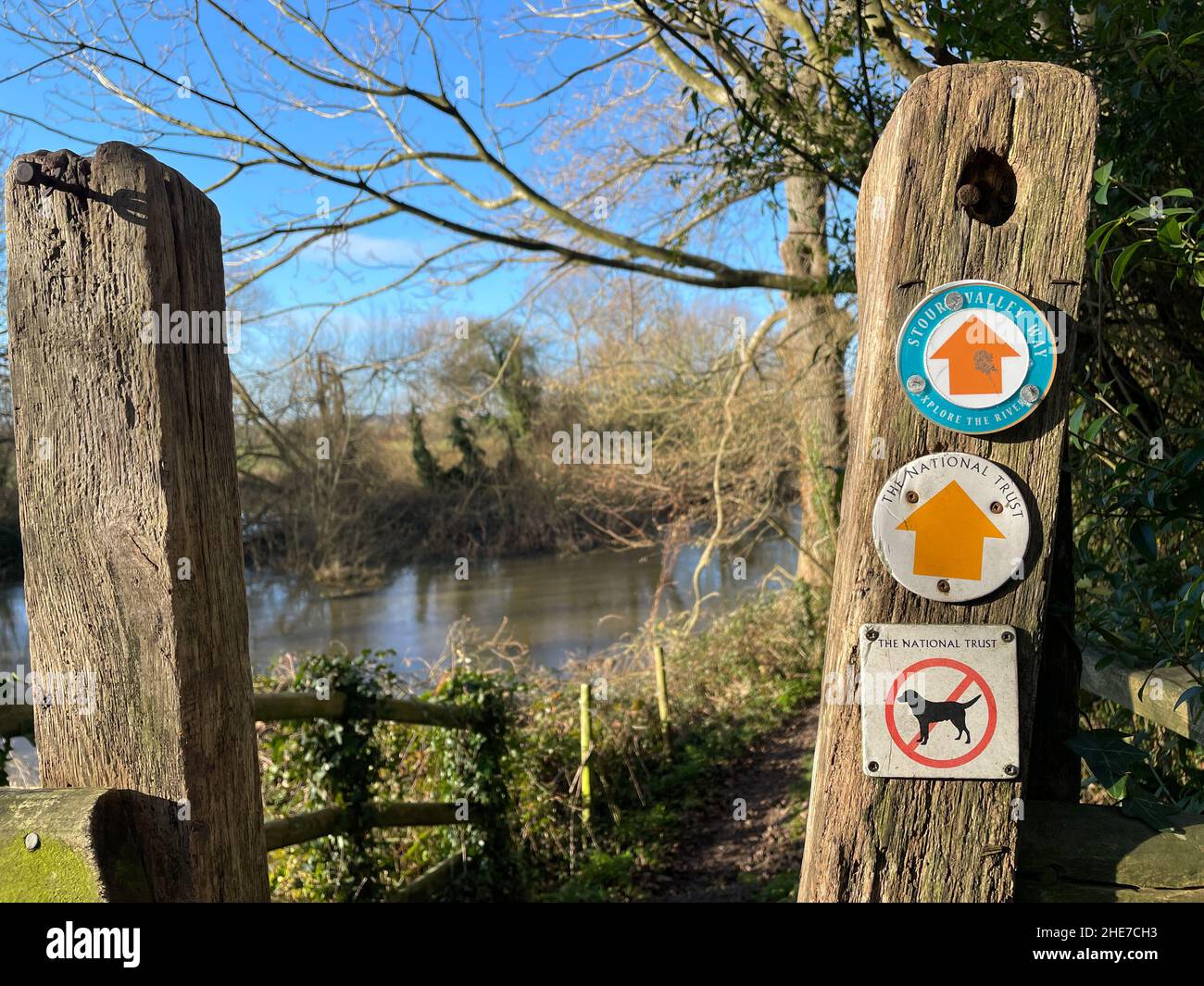 Various signs on a wooden post indicate The National Trust walking ...