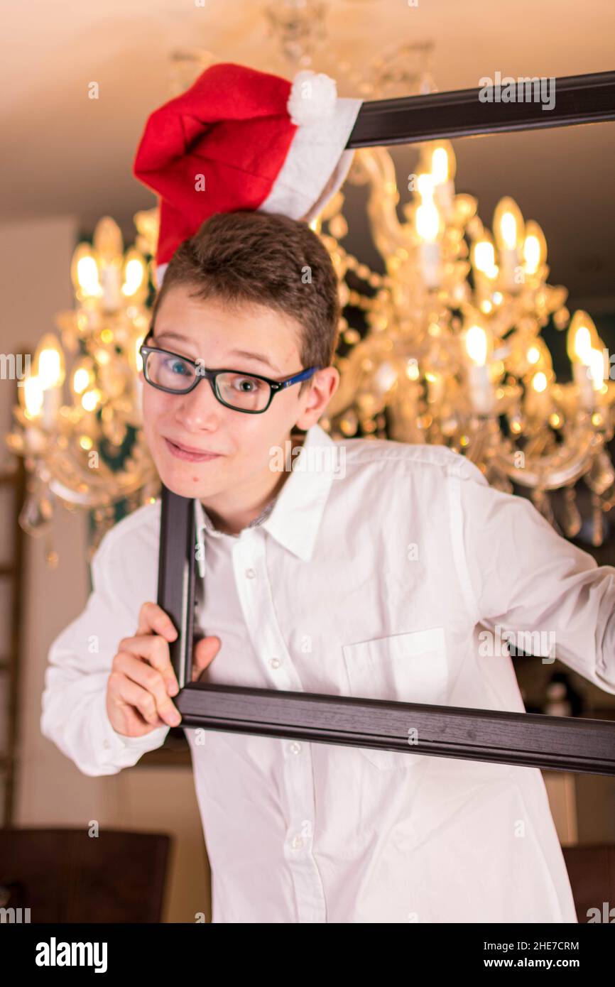 Boy with glasses and white shirt in front of festive candlestick and ...