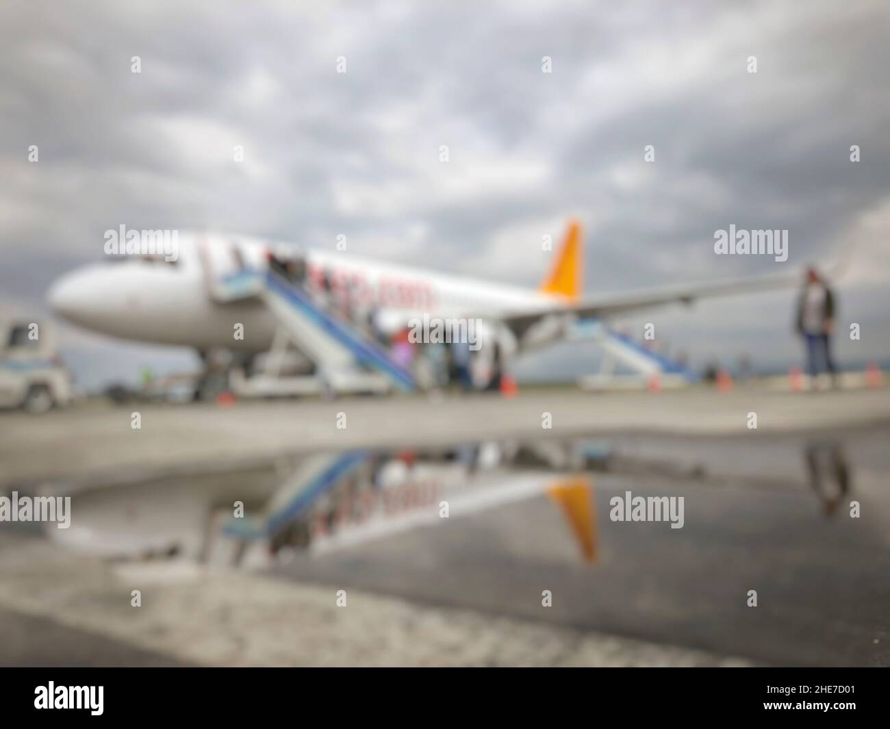 blurred background with people getting off a plane on the airport ...