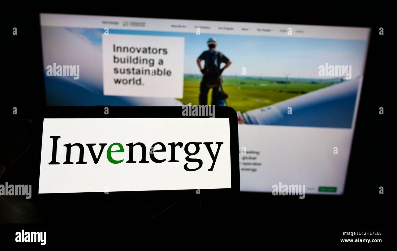 Person holding mobile phone with logo of American power generation ...