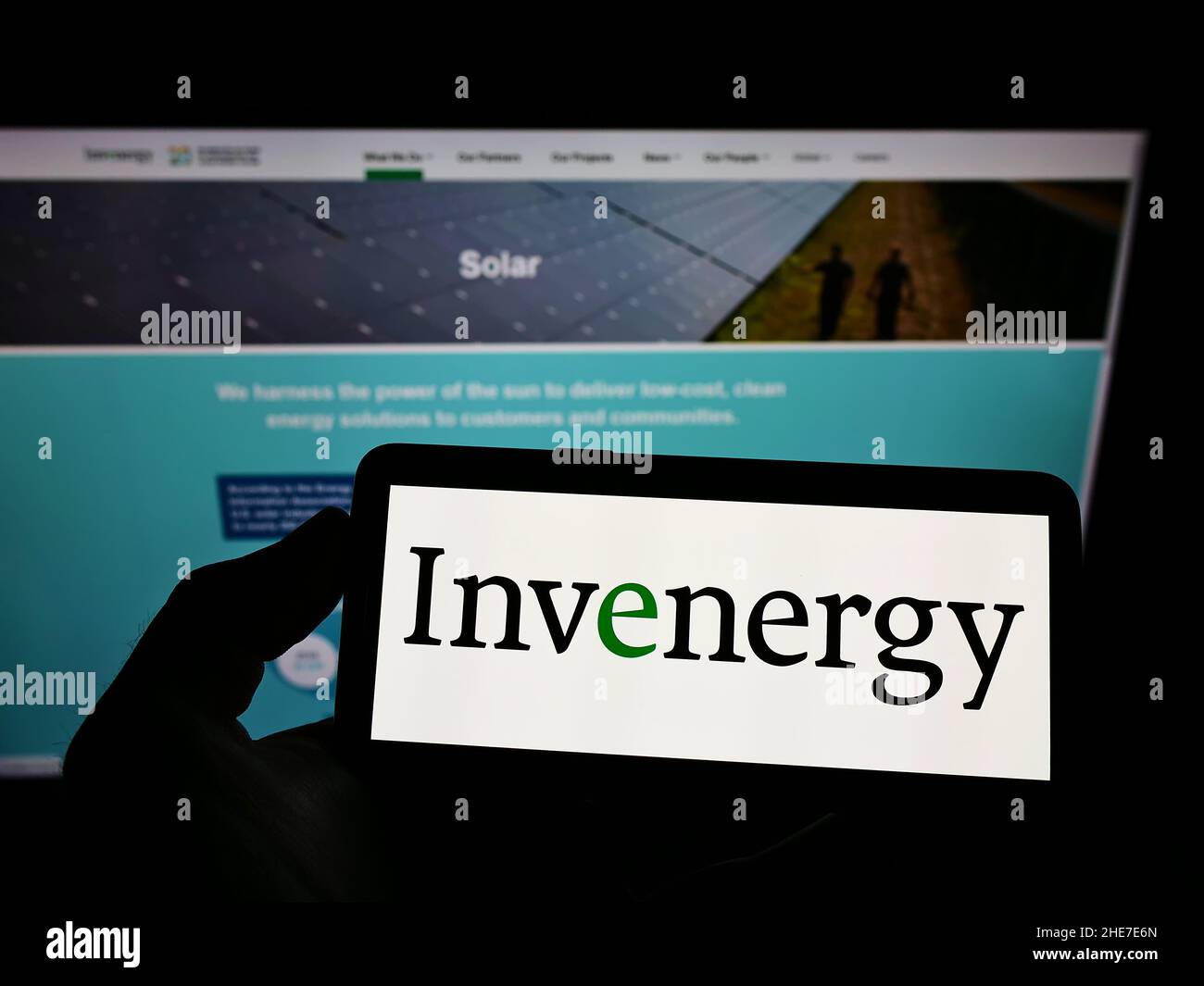 Person holding cellphone with logo of US power generation company ...