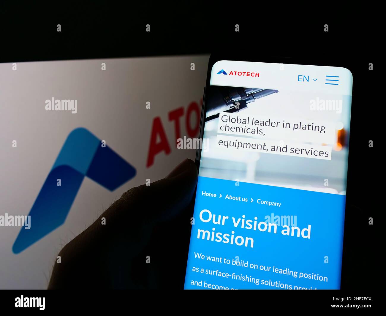 Person holding cellphone with webpage of chemical company Atotech ...