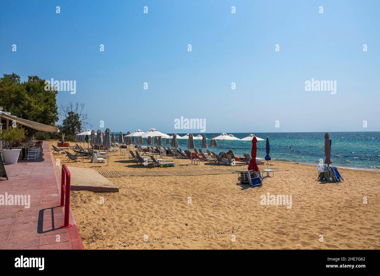 Amazing white sandy beach of Greece with empty sunbeds and umbrellas ...