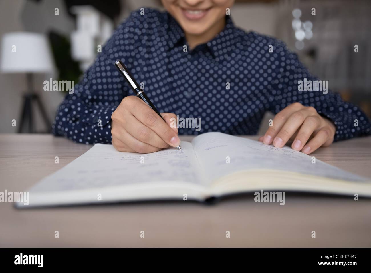 Happy ethnic girl making notes in notebook, list of tasks Stock Photo ...
