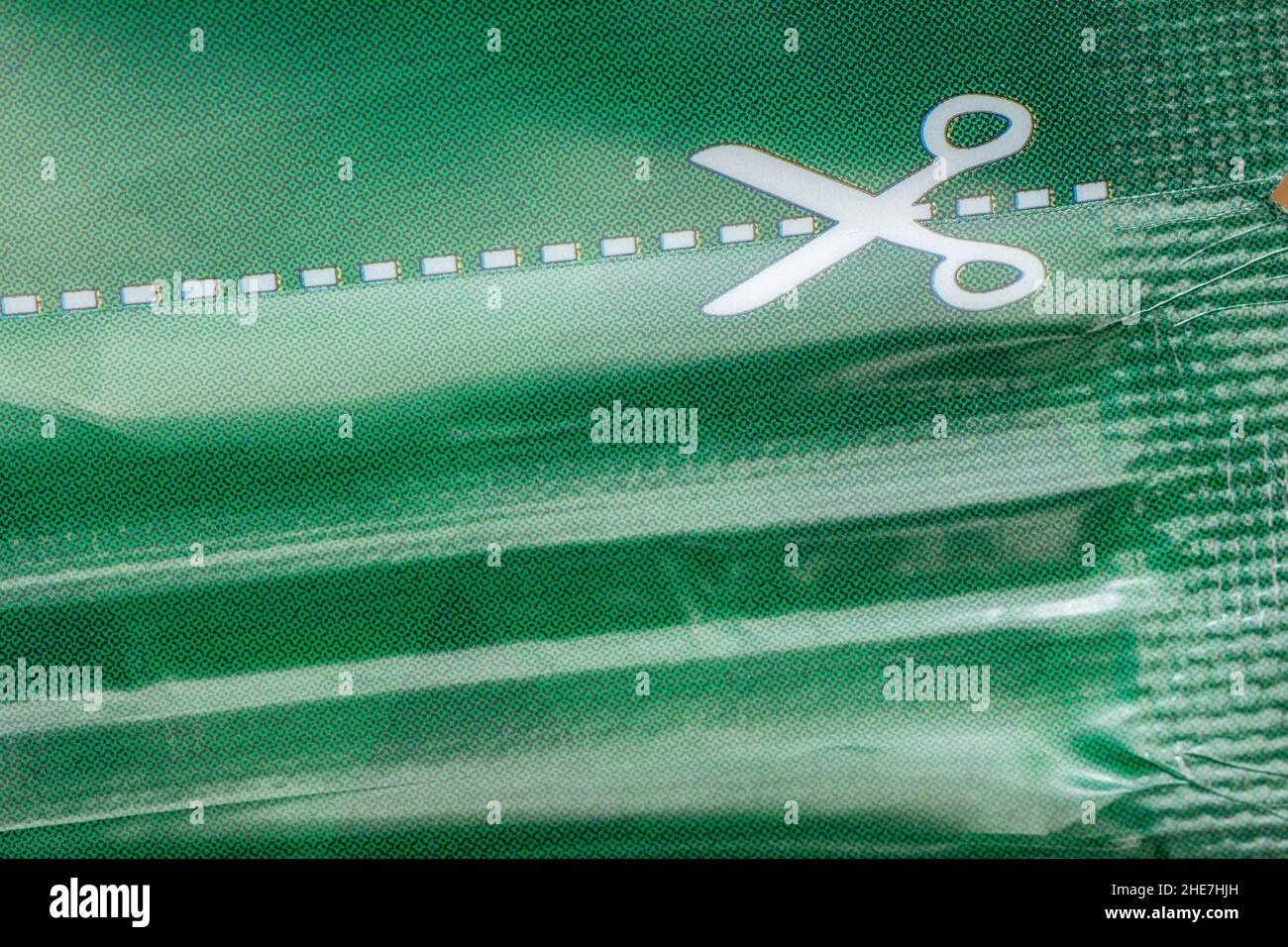 Macro shot of white scissors symbol and dotted cutting line on the ...