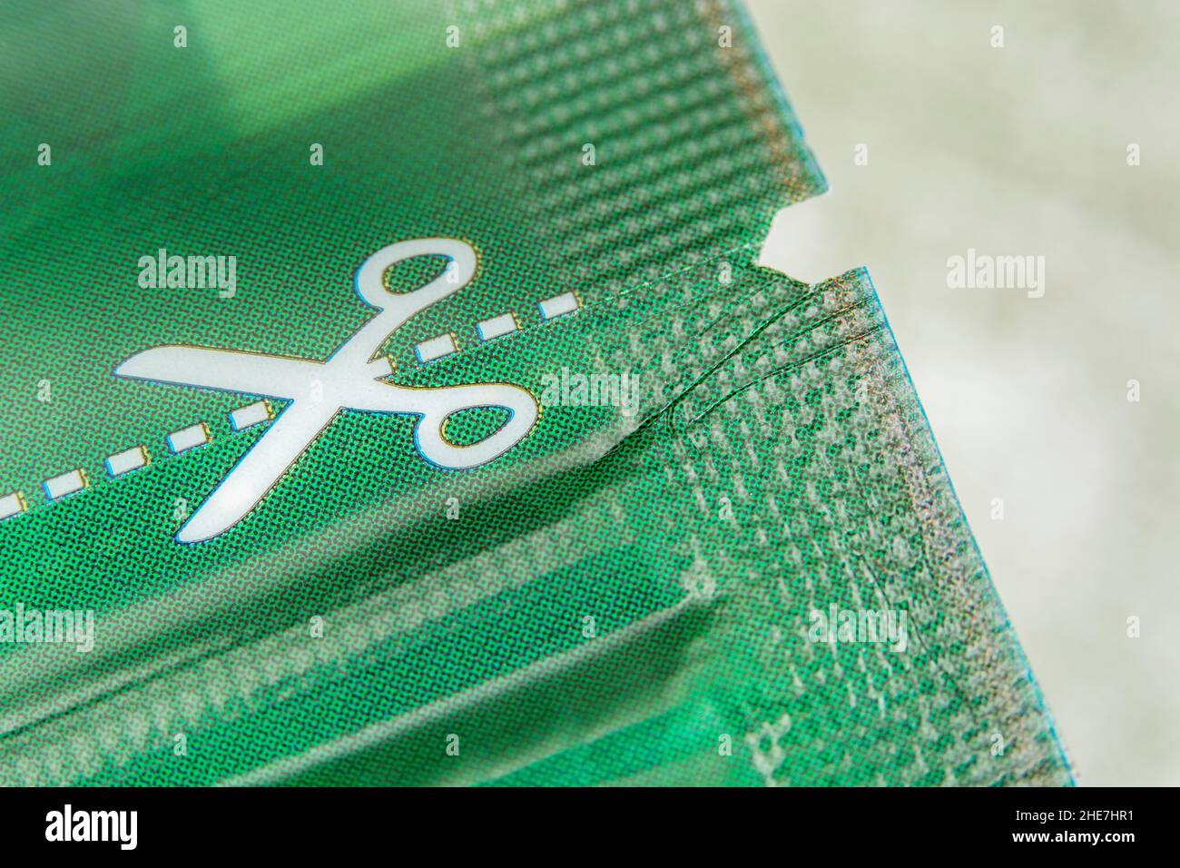 Extreme macro shot of white scissors symbol and dotted cutting line on ...
