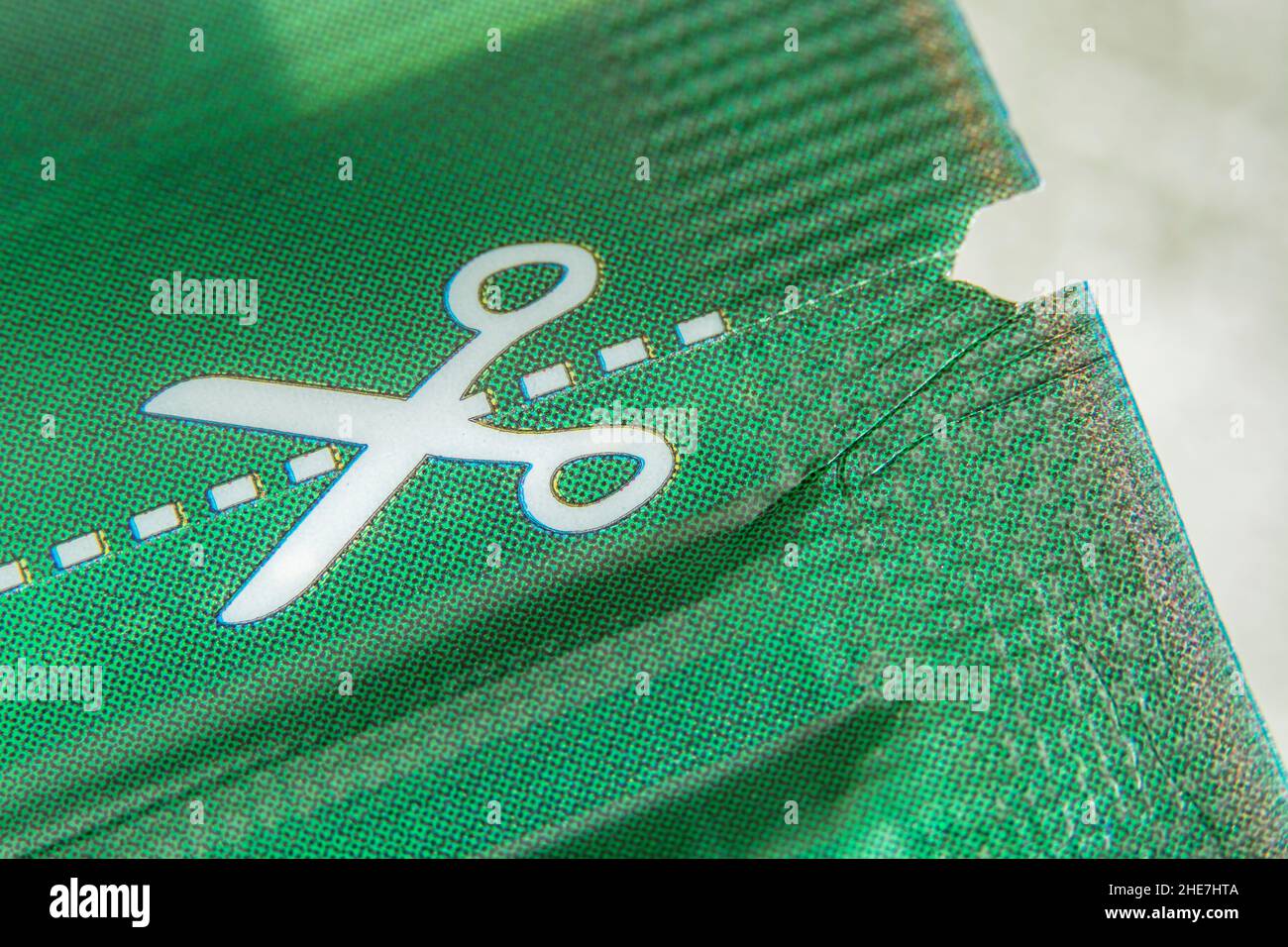 Extreme macro shot of white scissors symbol and dotted cutting line on ...