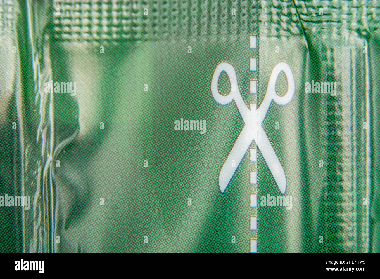 Extreme macro shot of white scissors symbol and dotted cutting line on ...