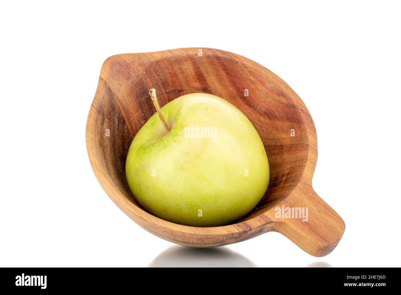 One sweet green apple with a wooden cup, close-up, isolated on white ...