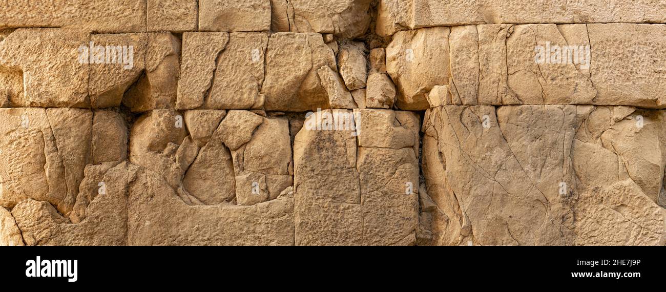 texture of an ancient wall made of huge stone blocks cracked from time ...