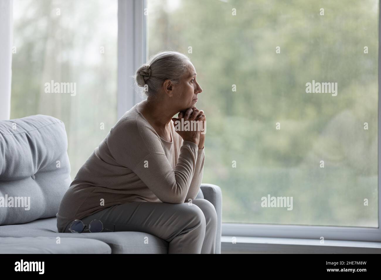 Pensive old mature woman looking in distance Stock Photo - Alamy