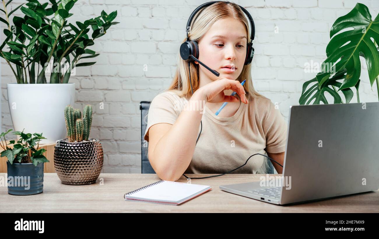 Student girl in headphones watching online video zoom class webinar in ...