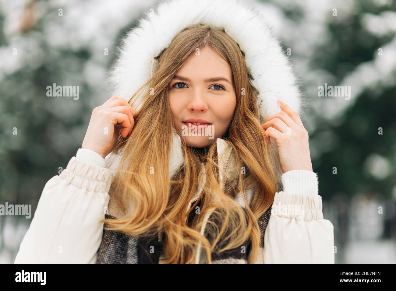 Beautiful woman standing among the snowy trees in the winter forest and ...