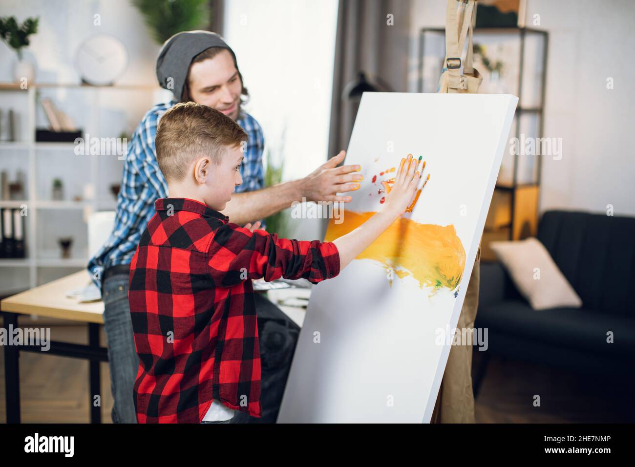 Cute little boy and his caring father using colorful paints for drawing ...