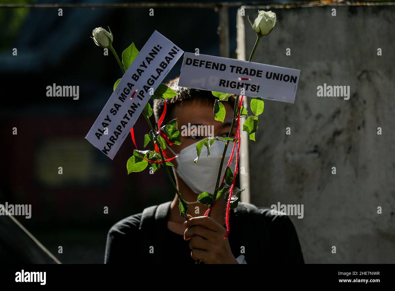 Human rights activists carry signs and offer flowers to remember fallen ...