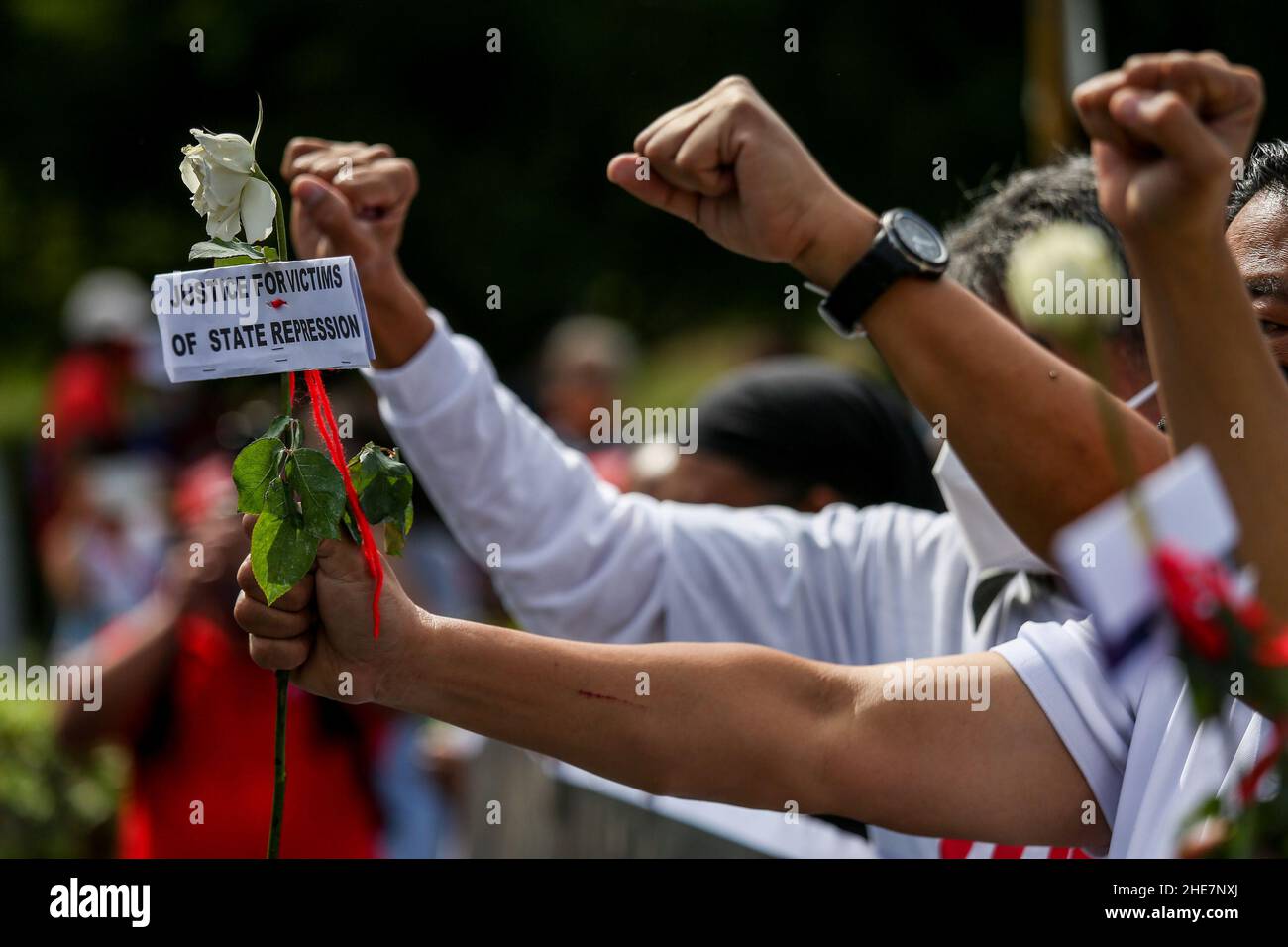 Human rights activists carry signs and offer flowers to remember fallen ...