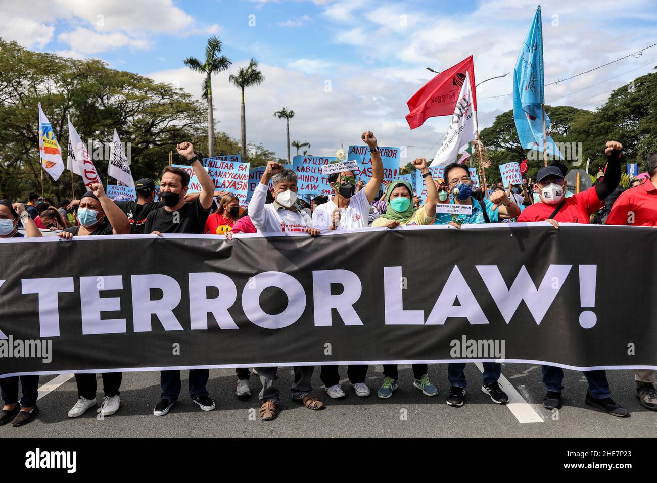 Human rights activists carry signs and offer flowers to remember fallen ...