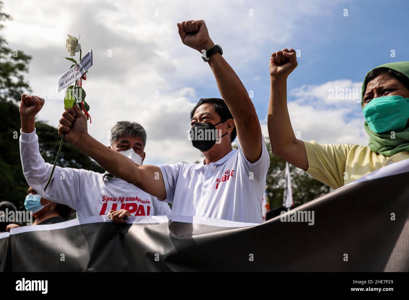 Human rights activists carry signs and offer flowers to remember fallen ...