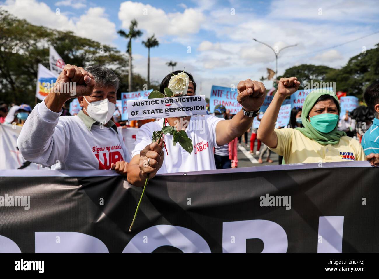 Human rights activists carry signs and offer flowers to remember fallen ...
