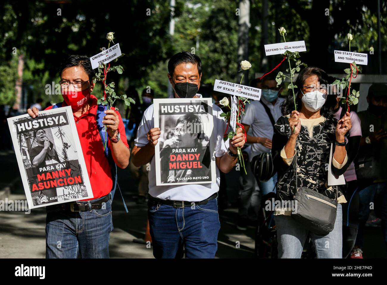 Human rights activists carry signs and offer flowers to remember fallen ...