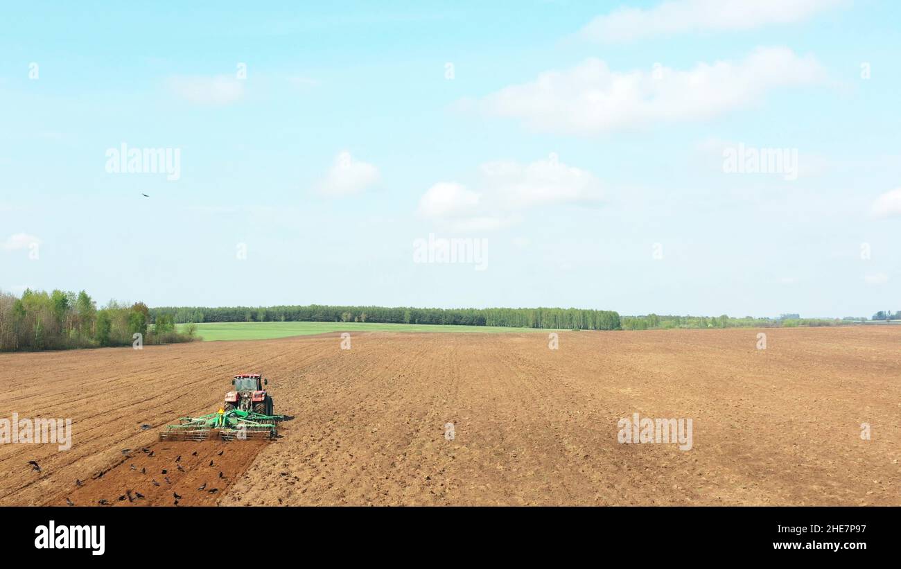 4K Aerial Flat View Tractor Plowing Field In Spring Season. Beginning ...