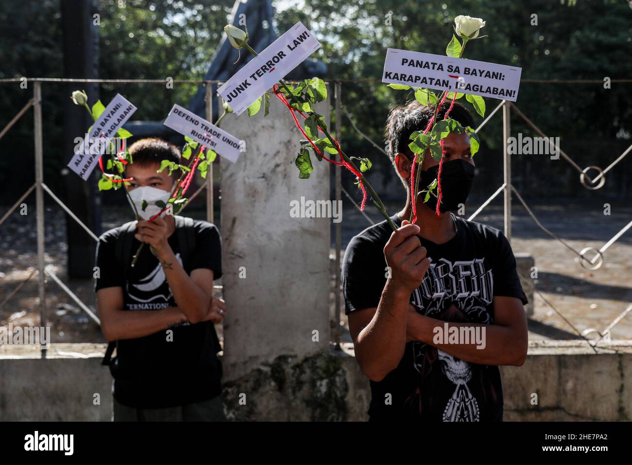 Human rights activists carry signs and offer flowers to remember fallen ...