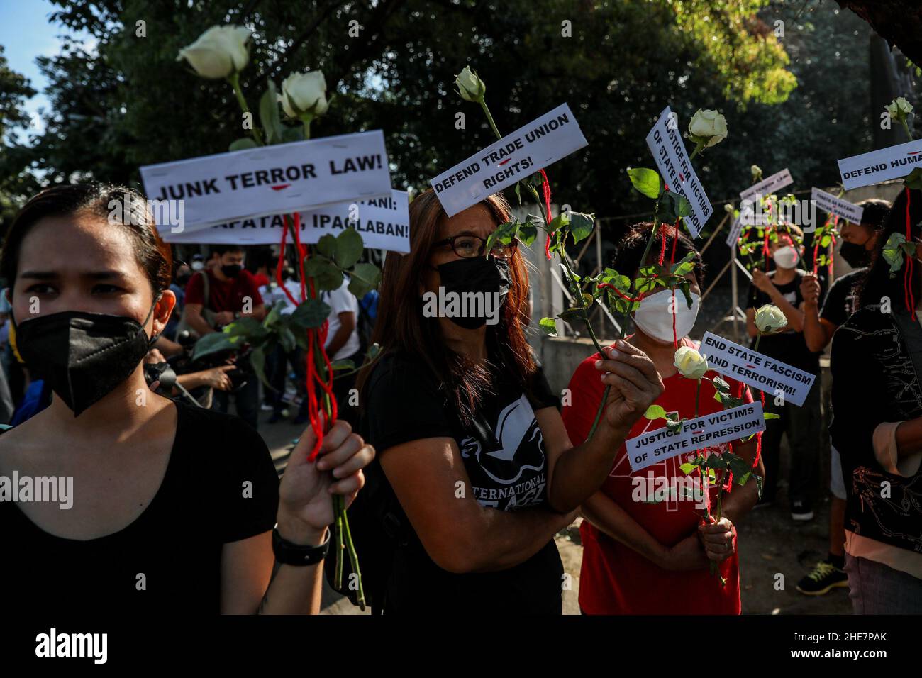 Human rights activists carry signs and offer flowers to remember fallen ...