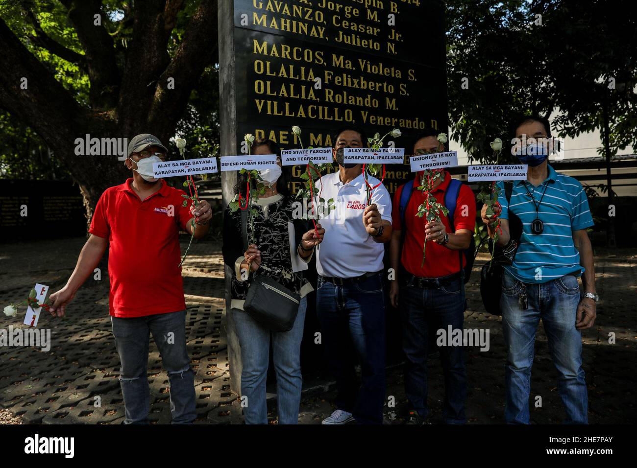 Human rights activists carry signs and offer flowers to remember fallen ...