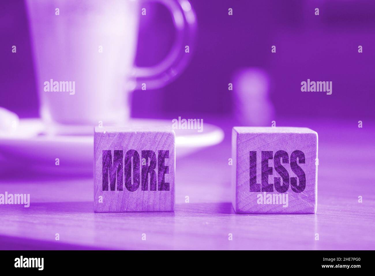 Wooden blocks on wooden table with More and Less signs. Decision making ...