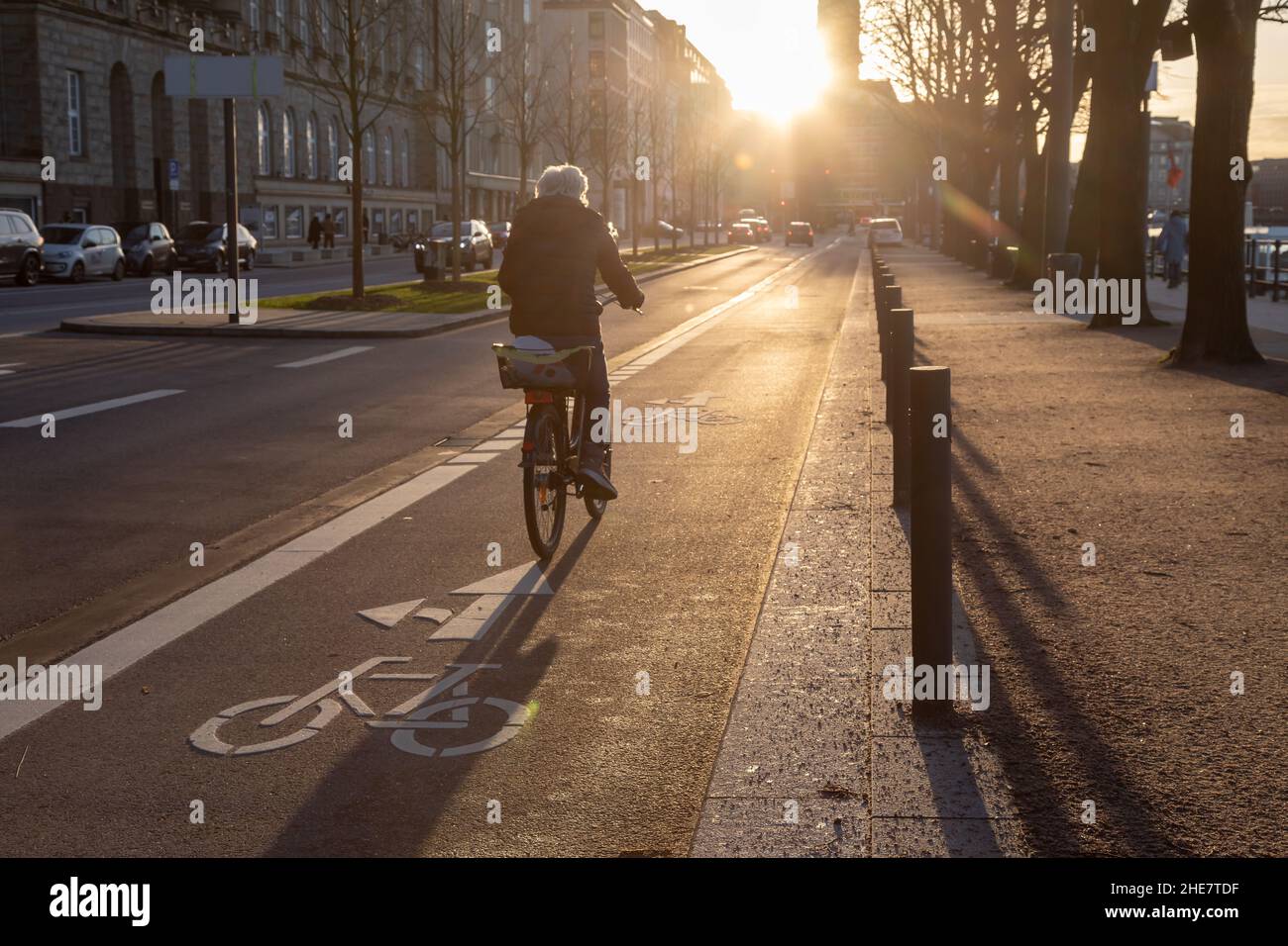Cyclist on cycle lane in the backlight Stock Photo - Alamy