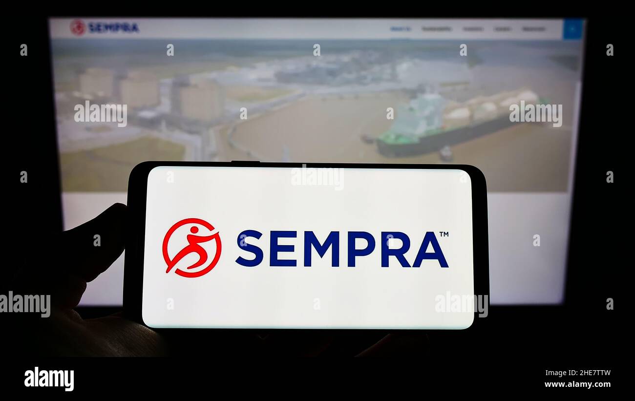 Person holding mobile phone with logo of American power and gas company ...
