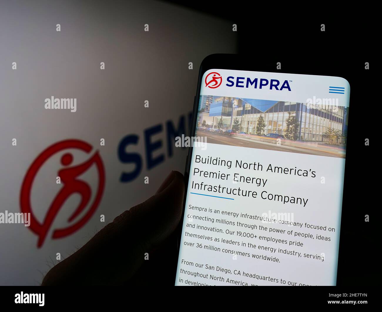 Person holding cellphone with webpage of US power and gas company ...