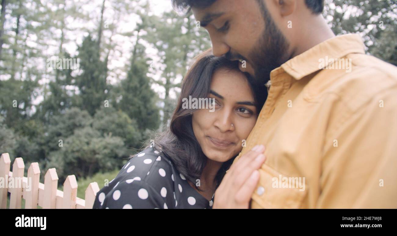 Young Indian woman leaning on her boyfriend's chest while having a date ...