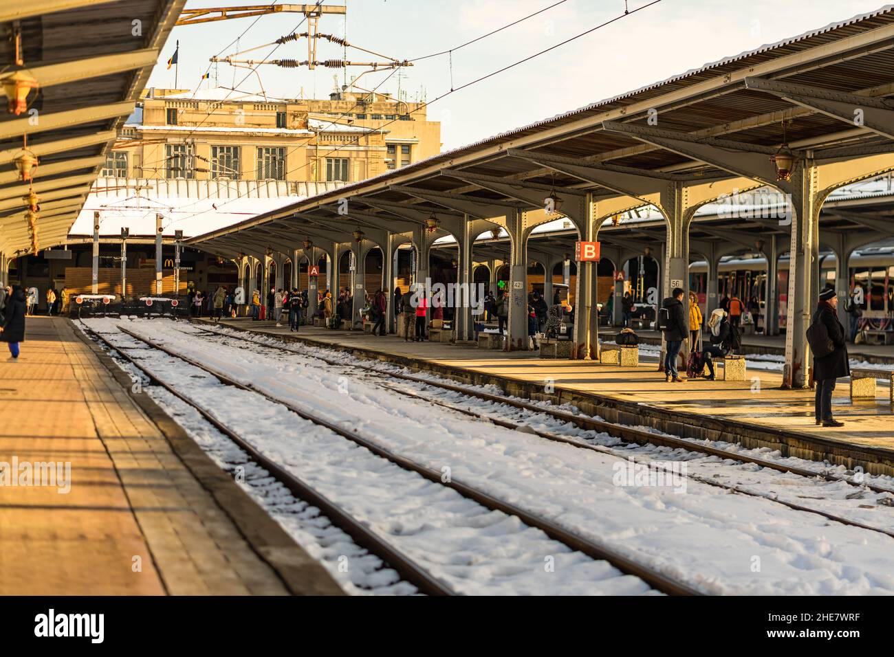 Travelers and commuters waiting for a train on the train platform of ...
