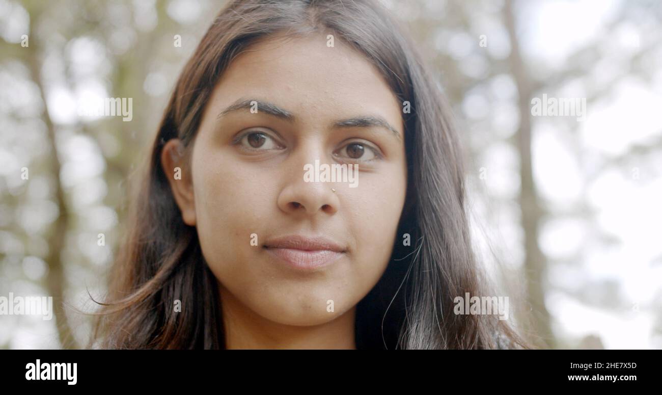 Portrait of a beautiful Indian woman against trees at a park Stock ...
