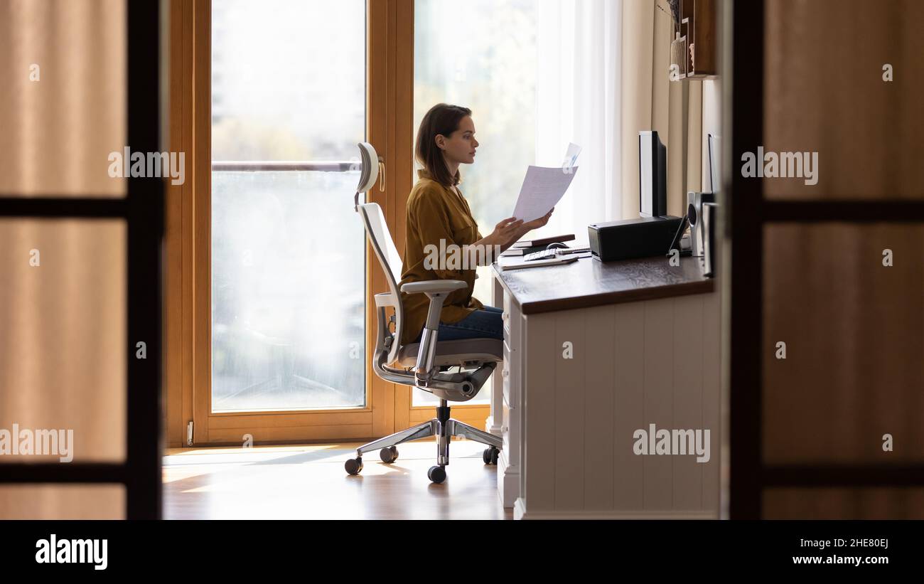 Serious home distance employee doing paperwork at table Stock Photo - Alamy