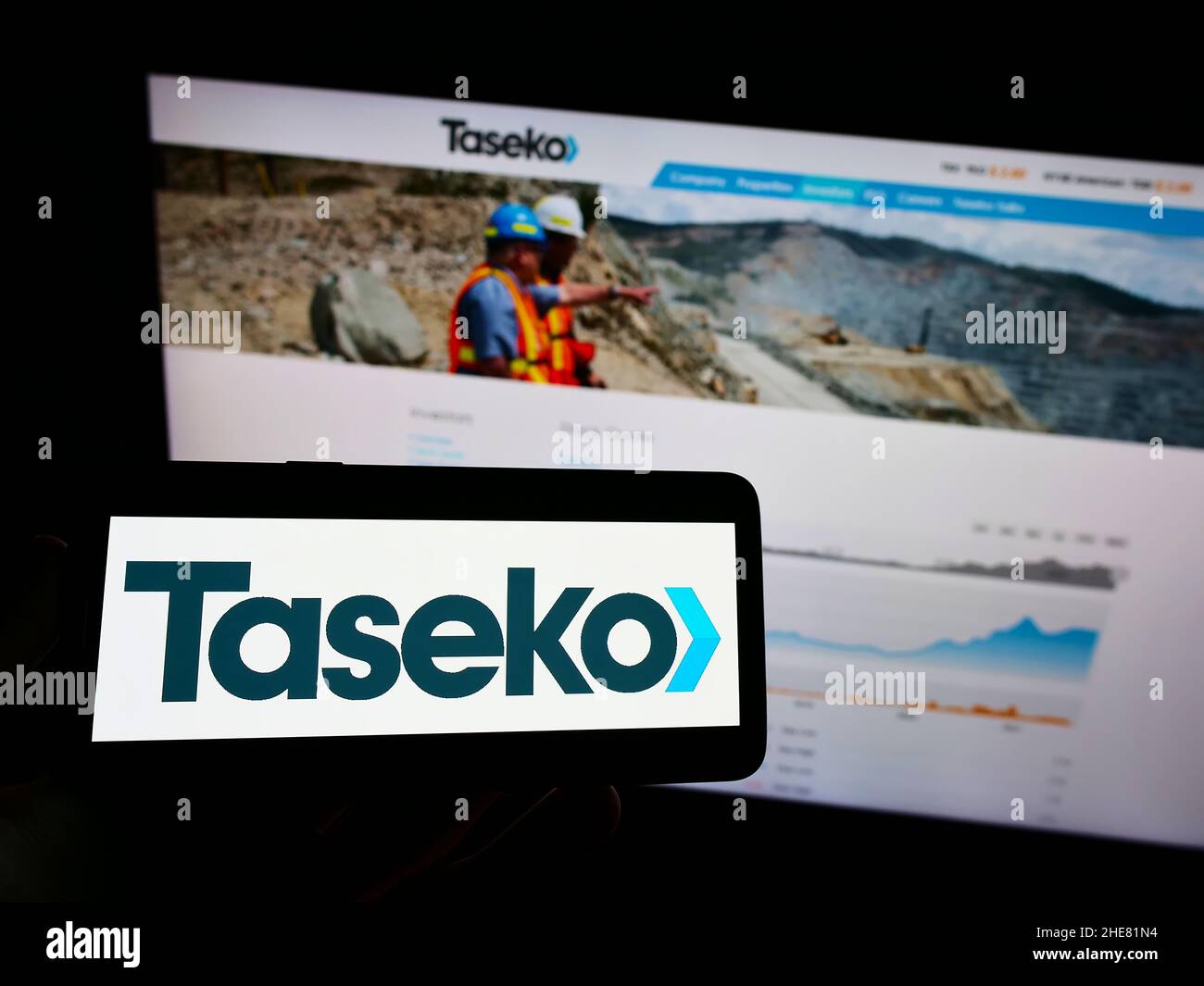 Person holding mobile phone with logo of Canadian mining company Taseko ...