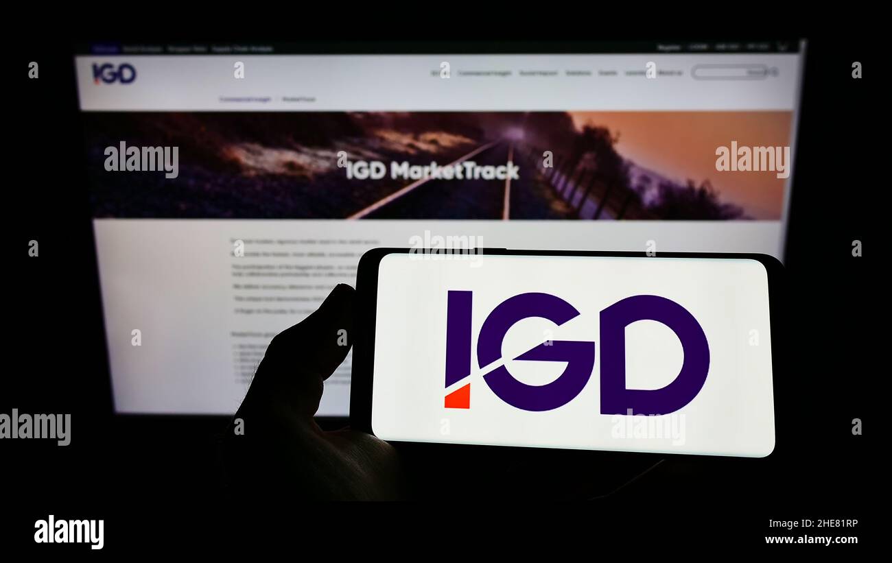 Person holding cellphone with logo of Institute of Grocery Distribution ...