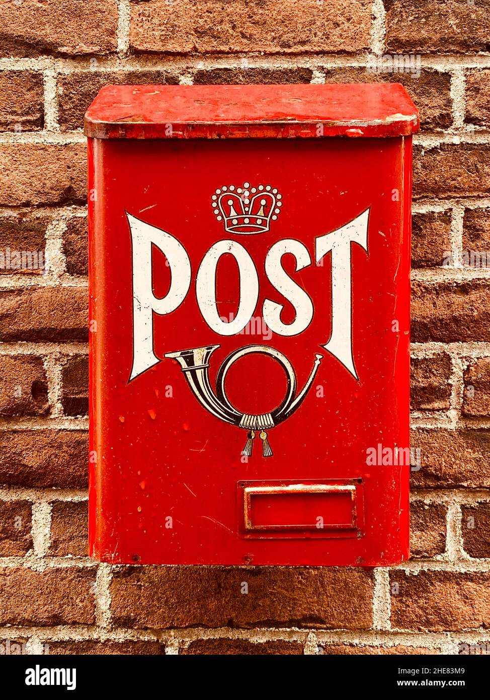 Traditional old bright red metal post box with word and picture of horn ...