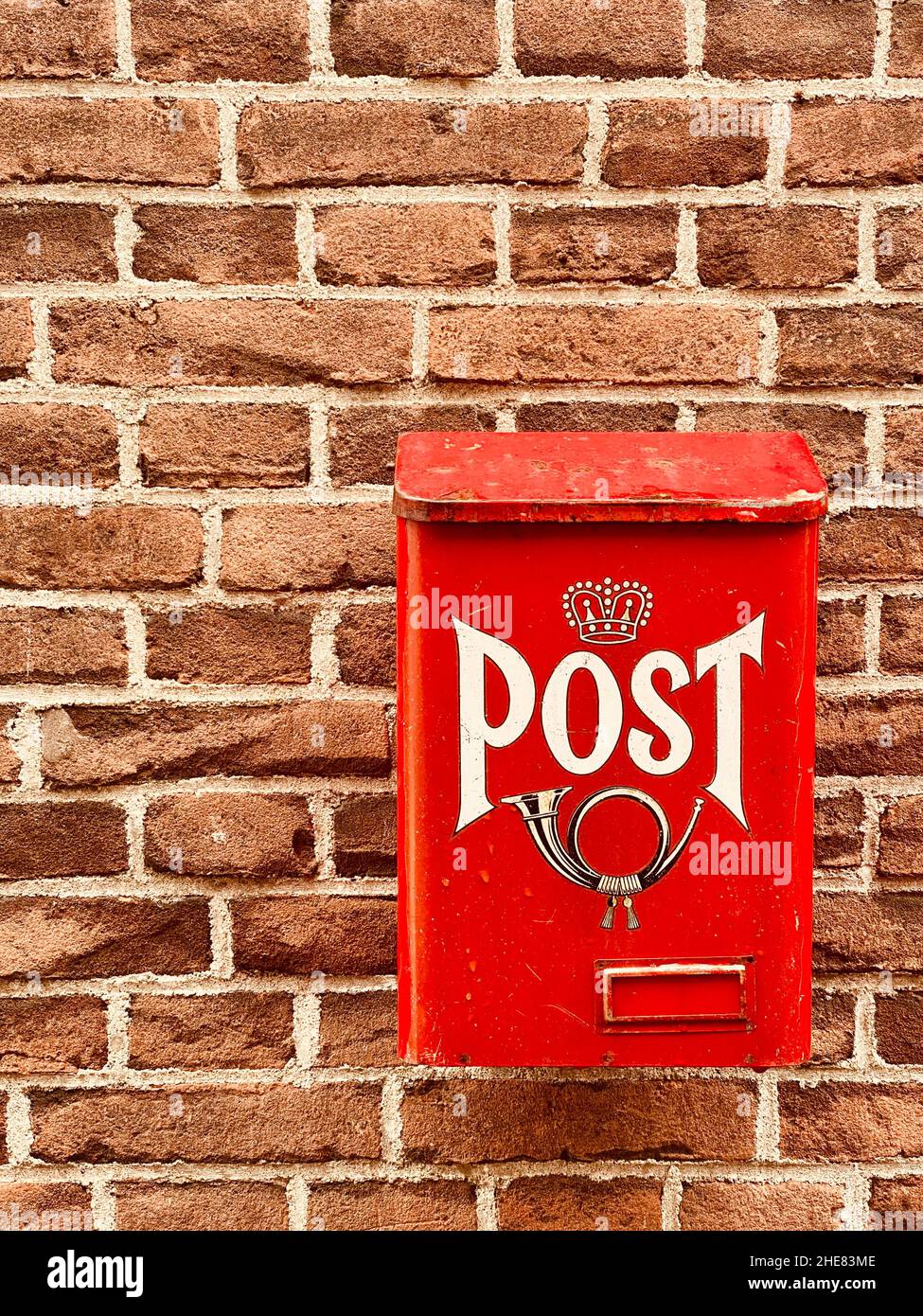 Traditional old bright red metal post box with word and picture of horn ...