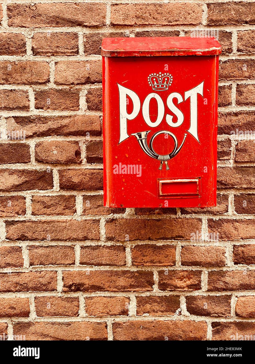 Traditional old bright red metal post box with word and picture of horn ...